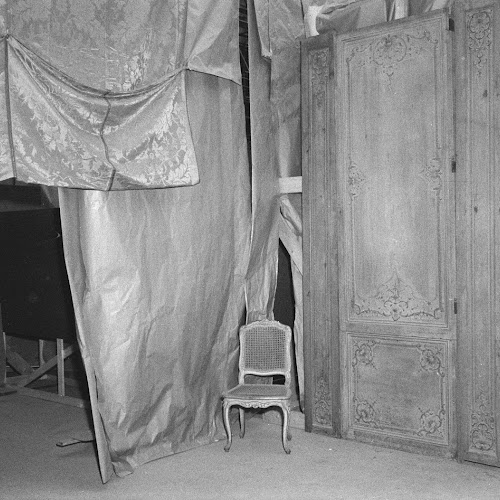 Betimmering met fauteuil tegen achtergrond van lappen stof of vellen ...